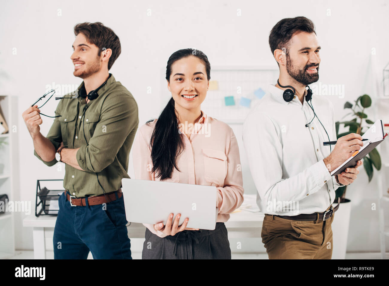 happy office managers smiling and standing in office Stock Photo - Alamy
