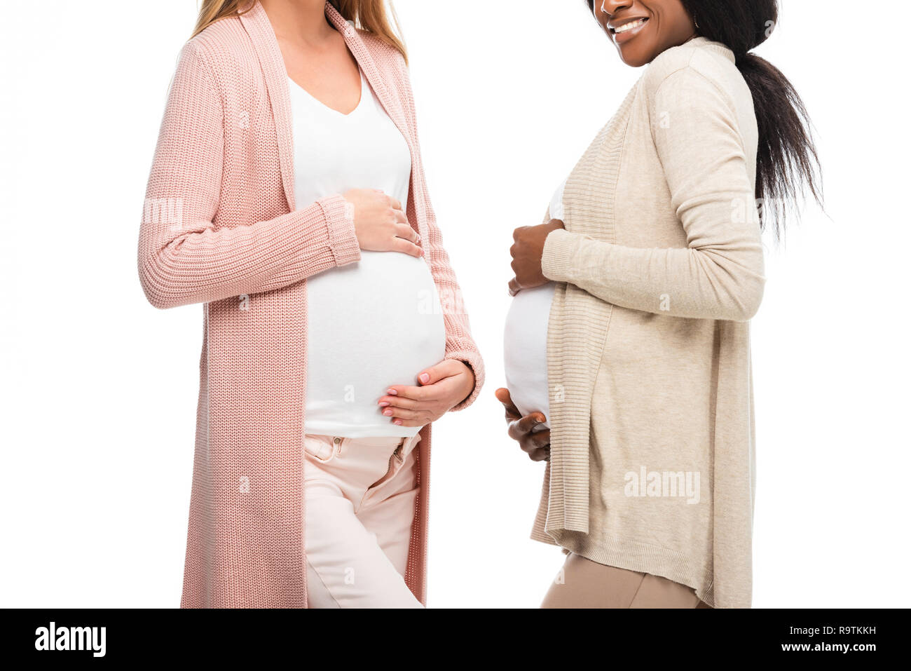 partial view of multicultural pregnant women smiling isolated on white ...