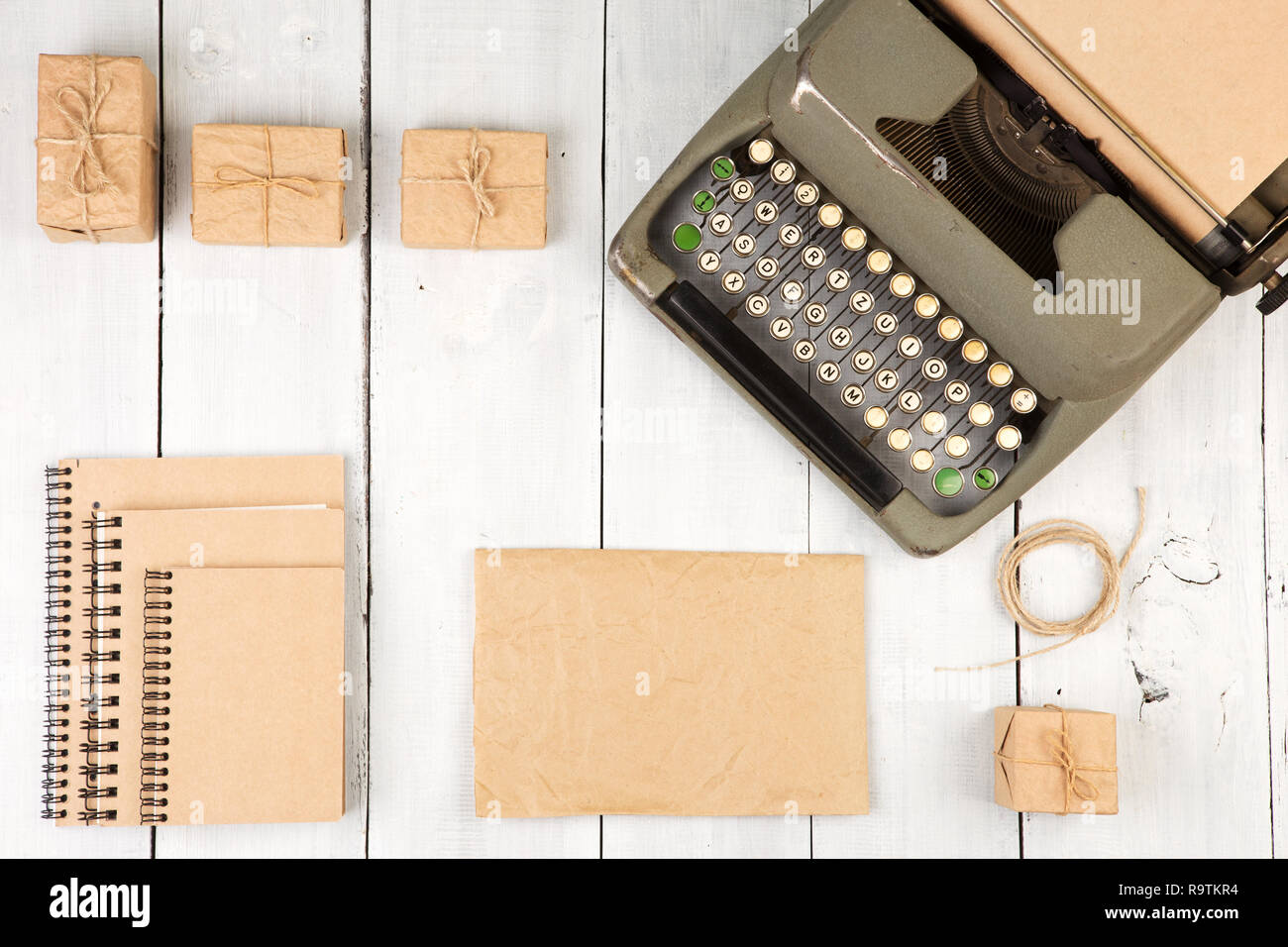Writer's workplace - vintage typewriter, notepads, present boxes on the ...