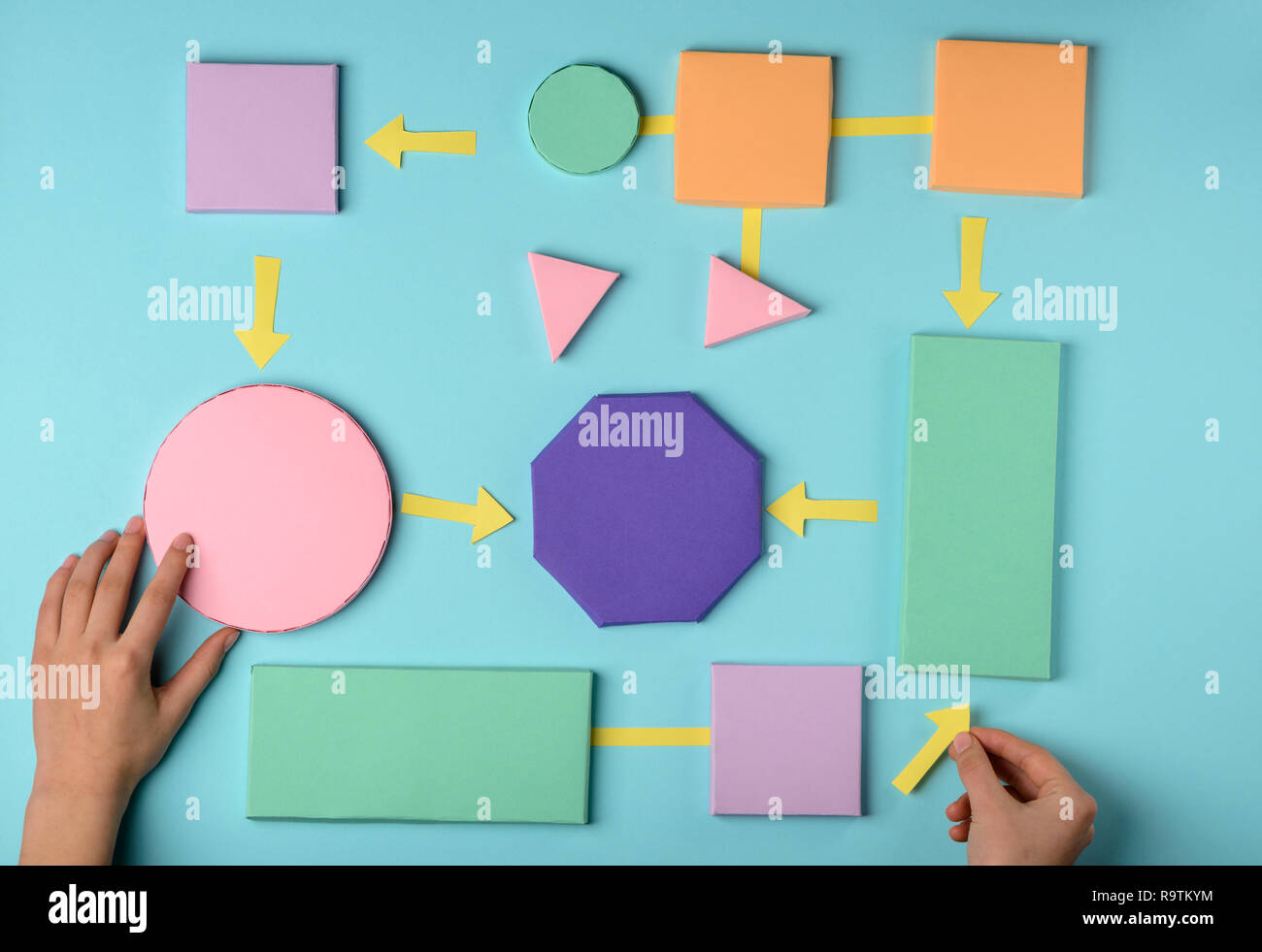 Woman's hands putting paper figures on blue background. Organizing a ...