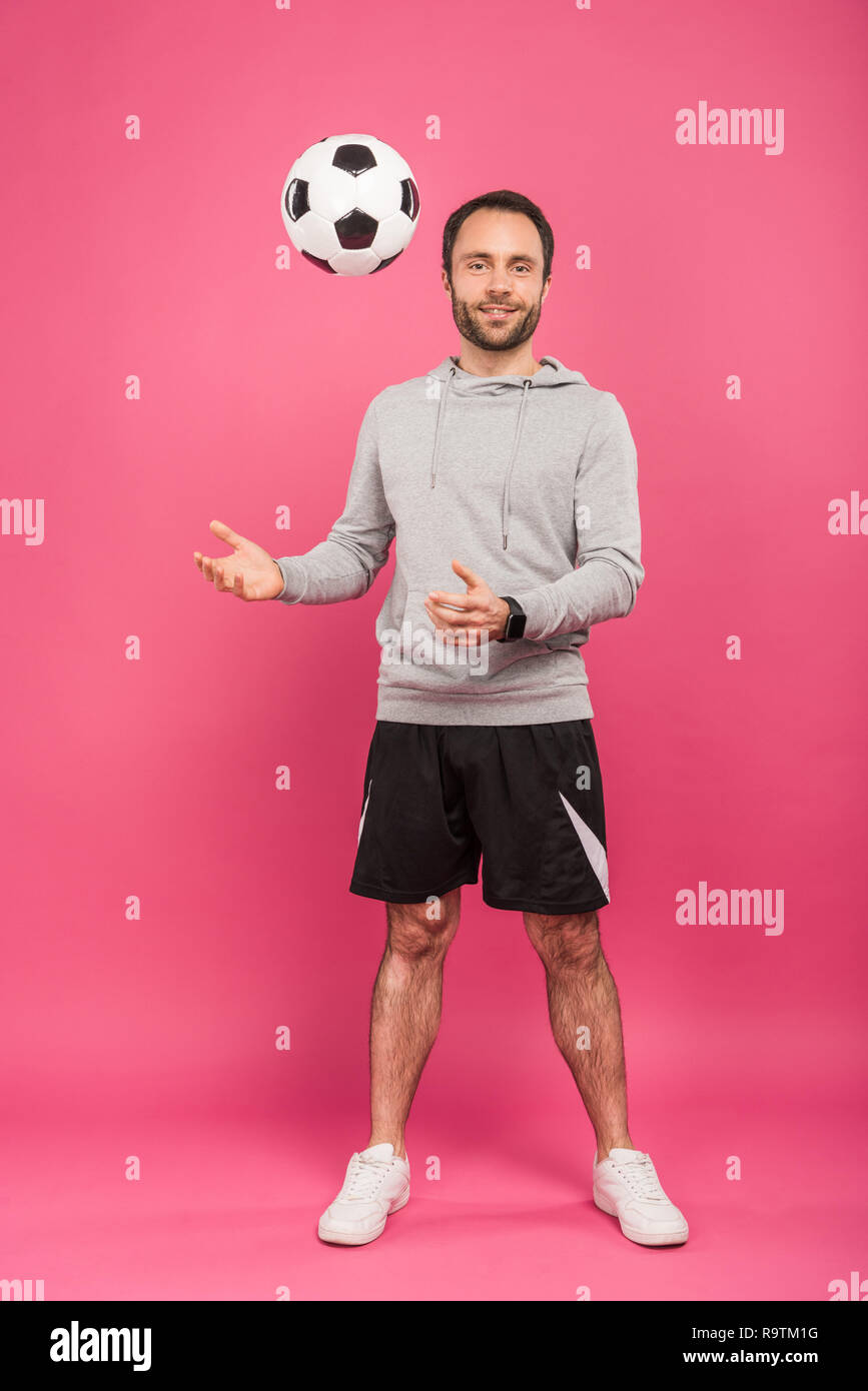 nale football player throwing up ball isolated on pink Stock Photo - Alamy