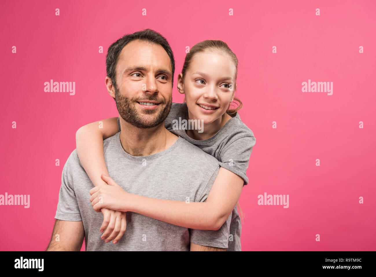 smiling blonde daughter hugging her dad, isolated on pink Stock Photo ...