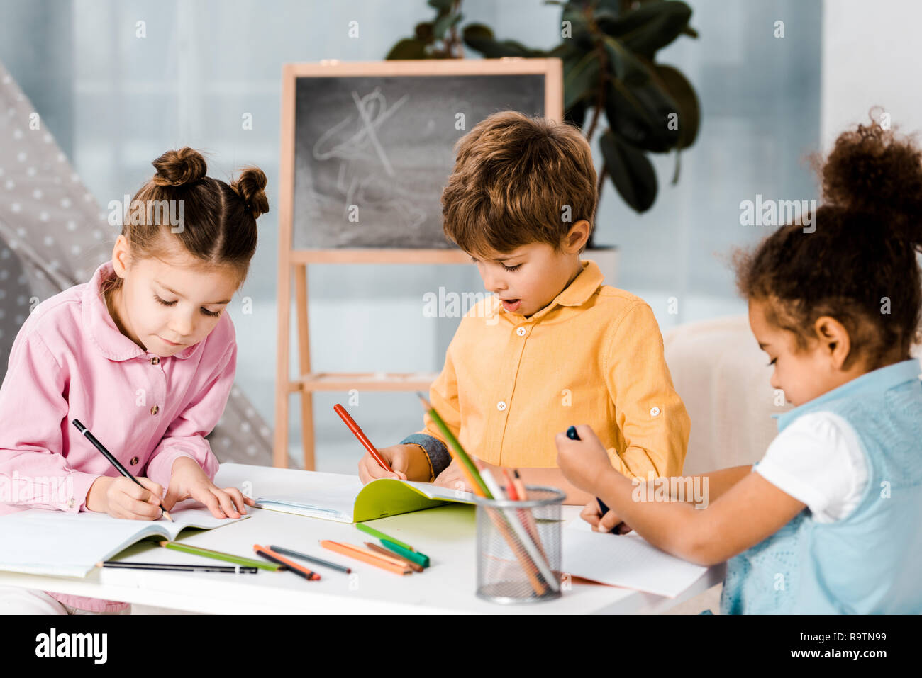 adorable little multiethnic kids drawing and studying together Stock ...
