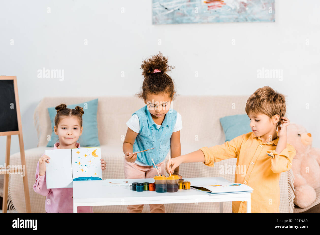 cute multiethnic children drawing with paints together Stock Photo - Alamy