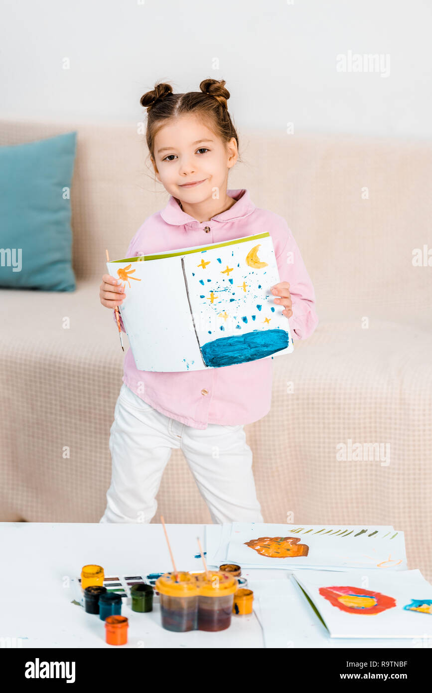 cute happy child holding picture and smiling at camera Stock Photo - Alamy