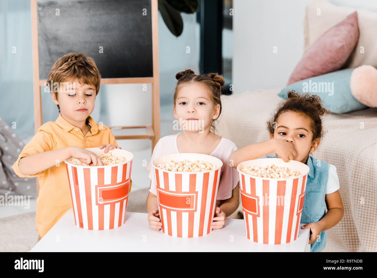 adorable multiethnic children eating popcorn from boxes Stock Photo - Alamy