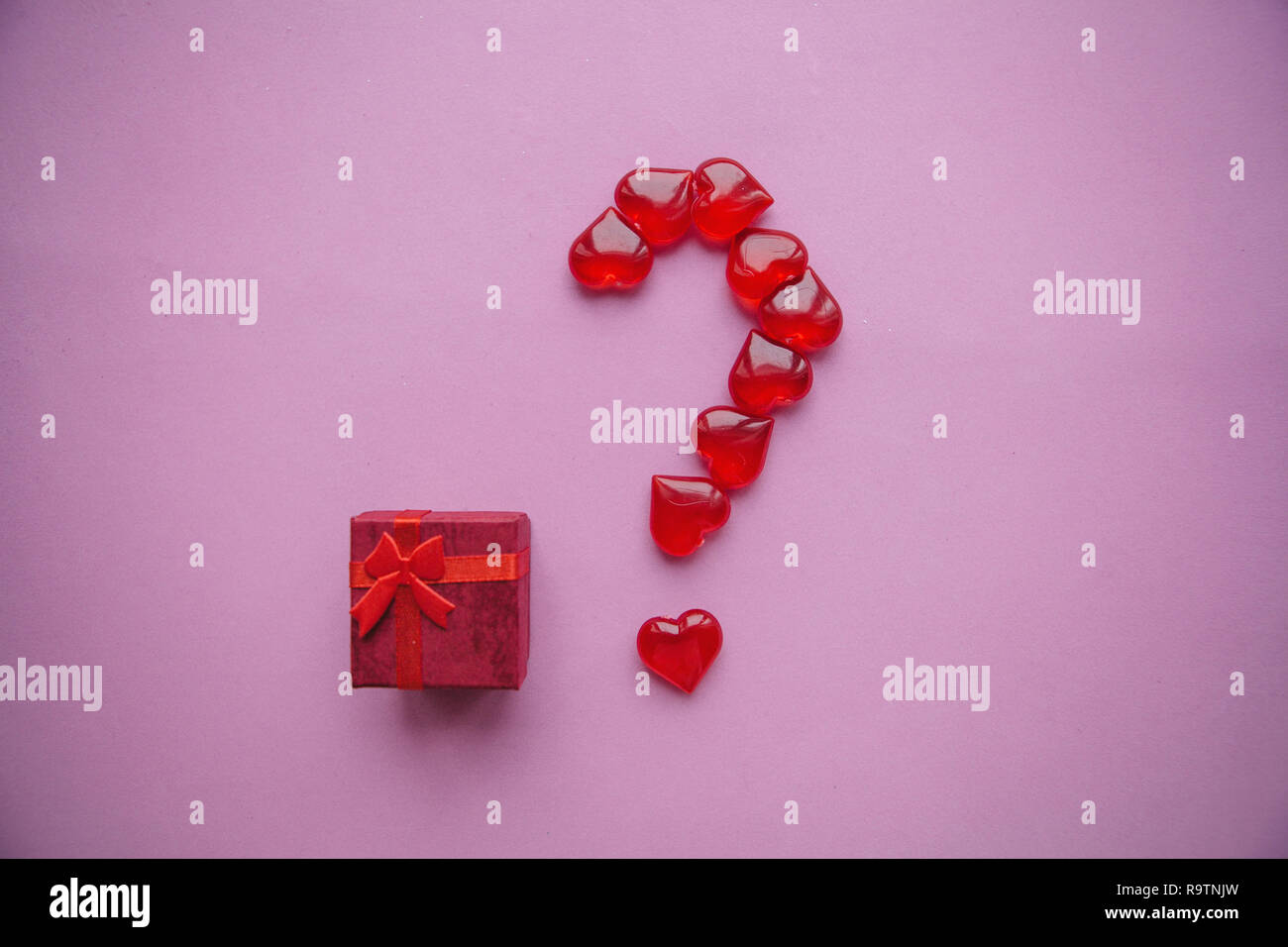 A box with a gift and a number of question marks laid out from small ...