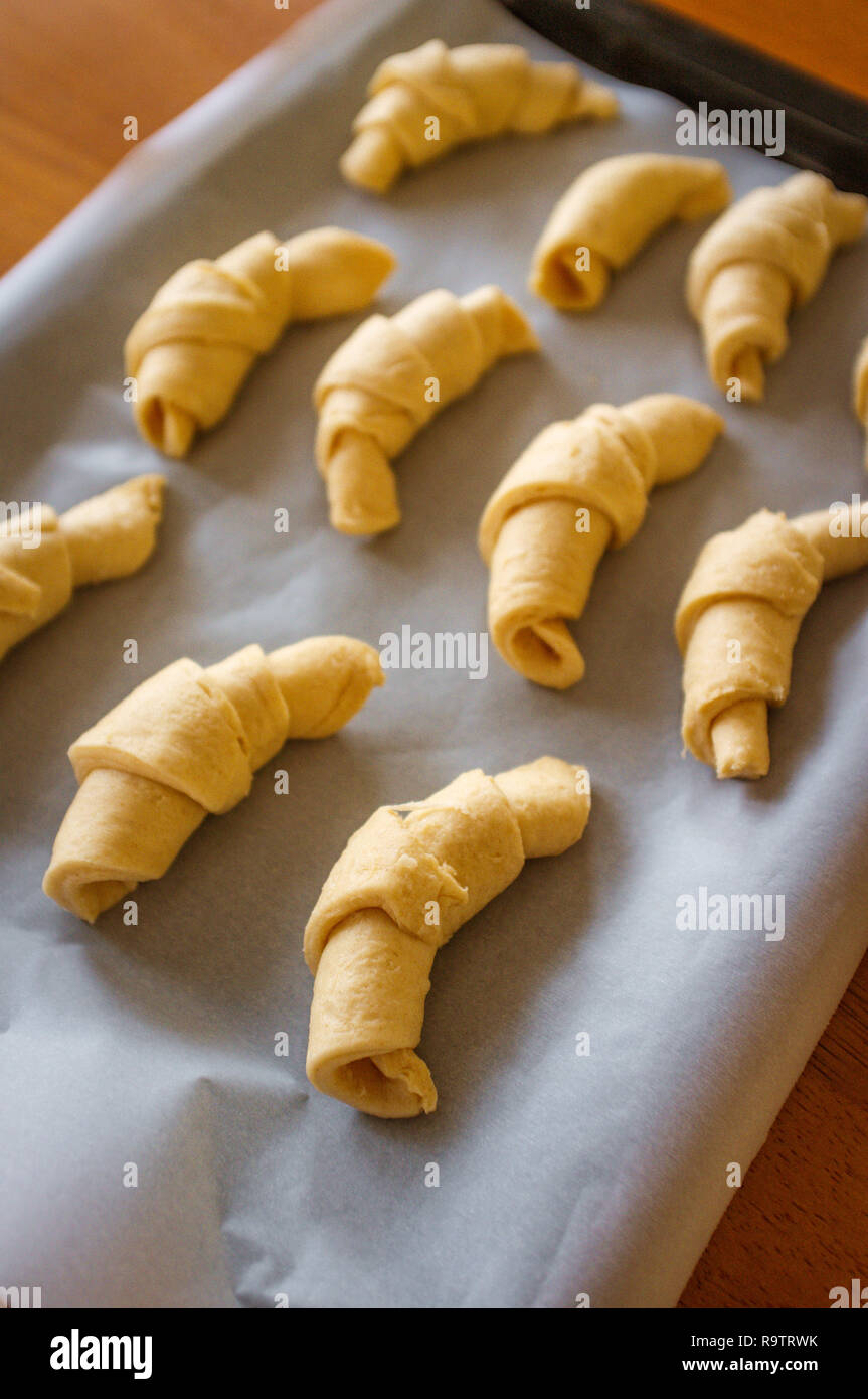 Raw croissant roll dough on parchment paper and pan ready for the oven ...