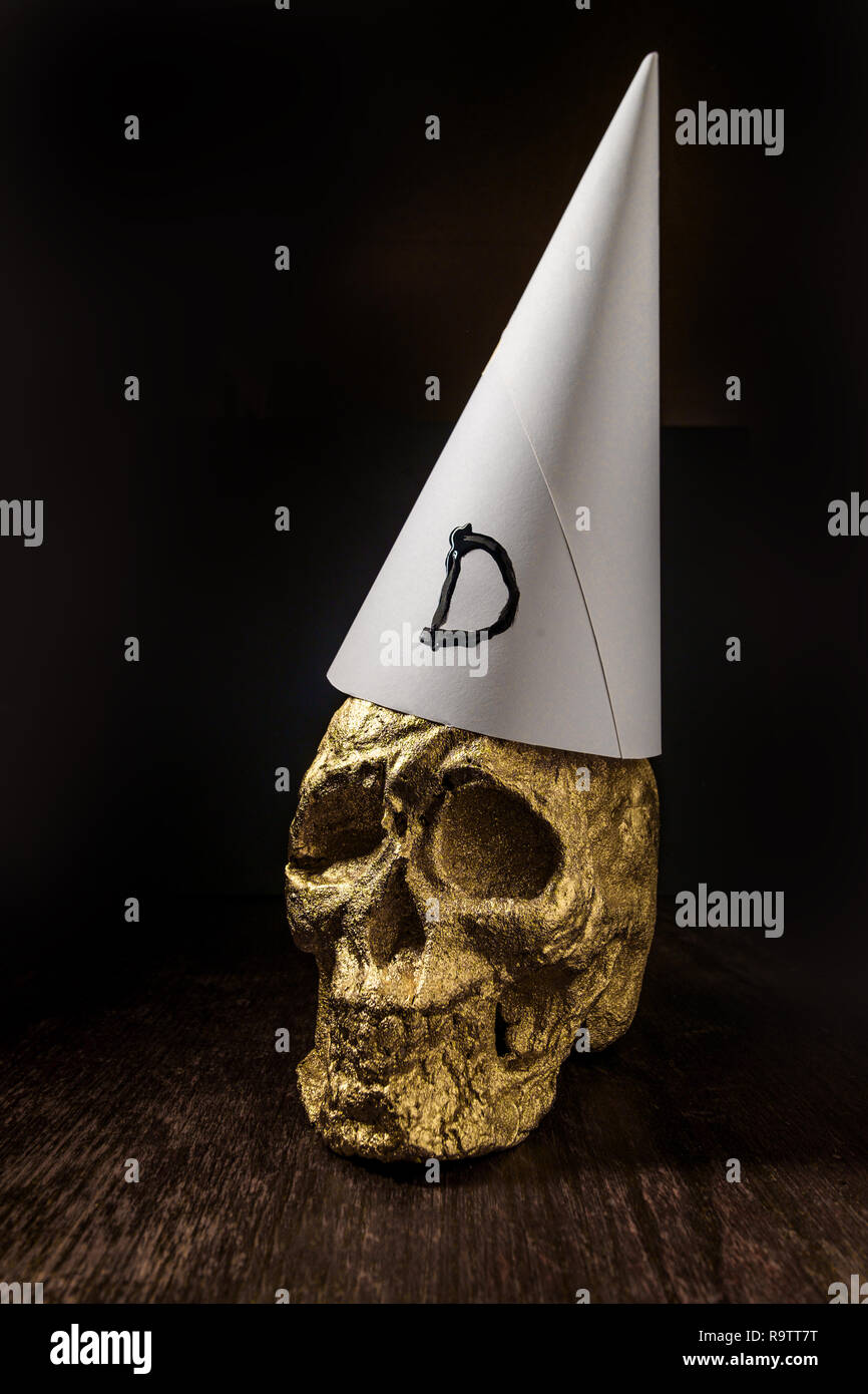 Gold skull fool made from fools gold wearing dunce cap Stock Photo - Alamy