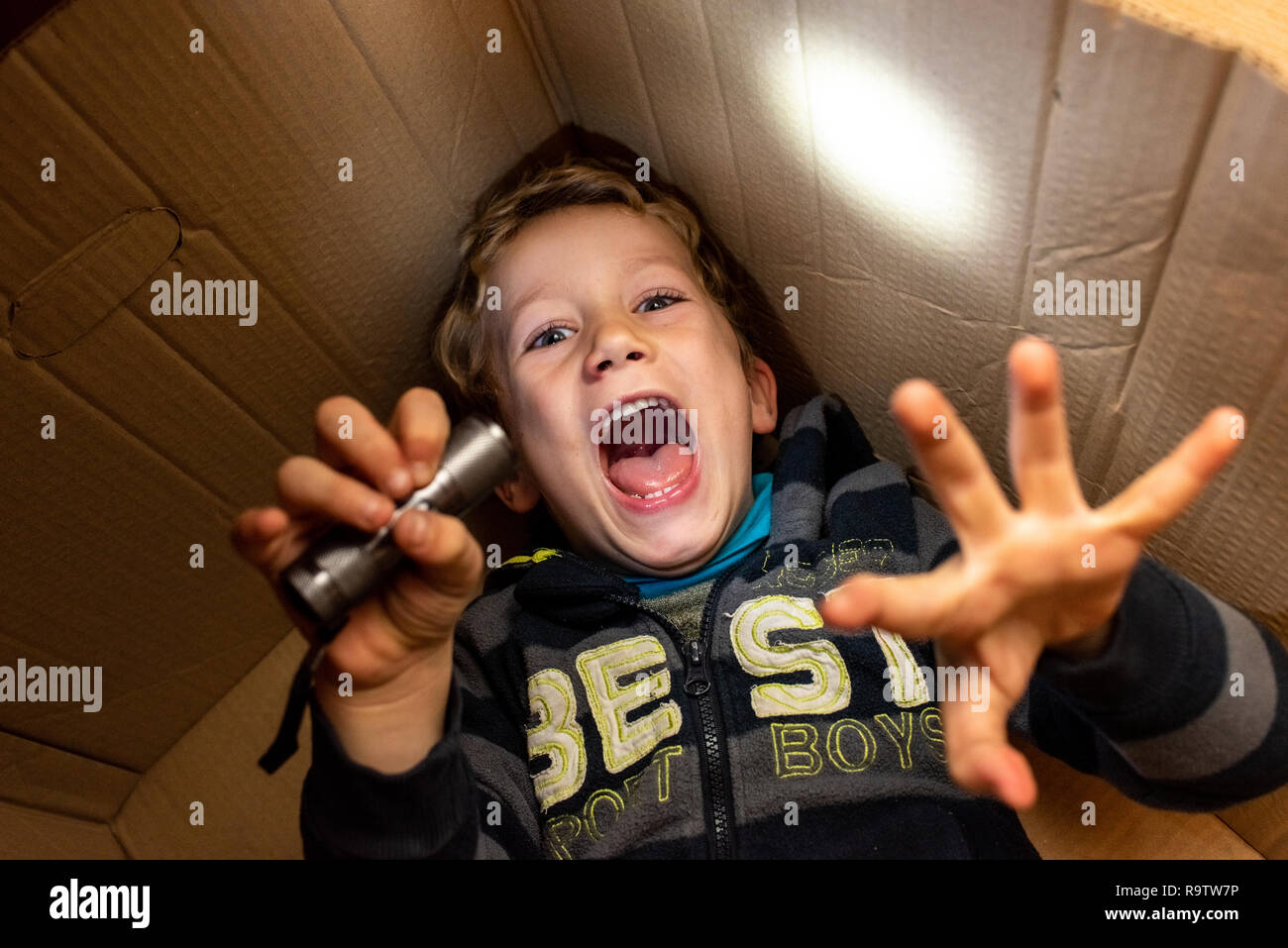 Child playing inside a cardboard box Stock Photo - Alamy
