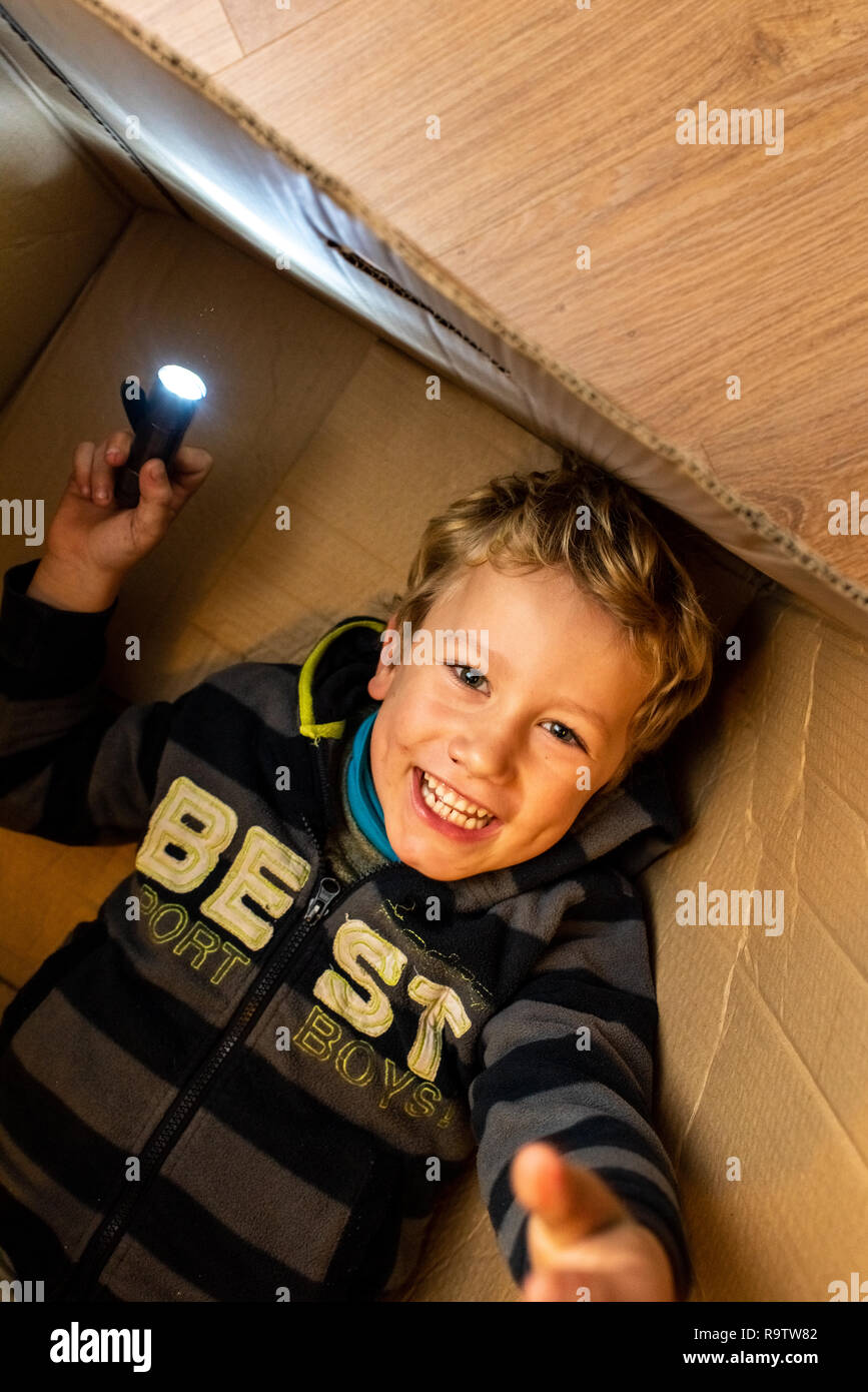Child playing inside a cardboard box Stock Photo - Alamy