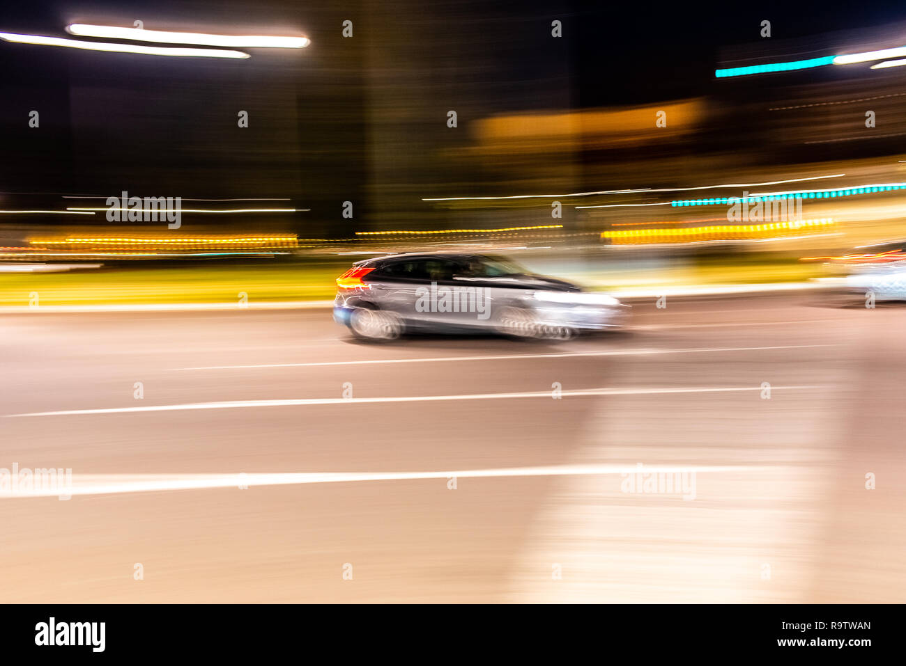 Car rolling at full speed through the city at night, image of panning ...
