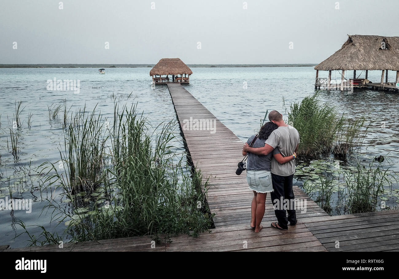 young couple hug on he wooden pier Mexico lagoon Bacalar Stock Photo ...