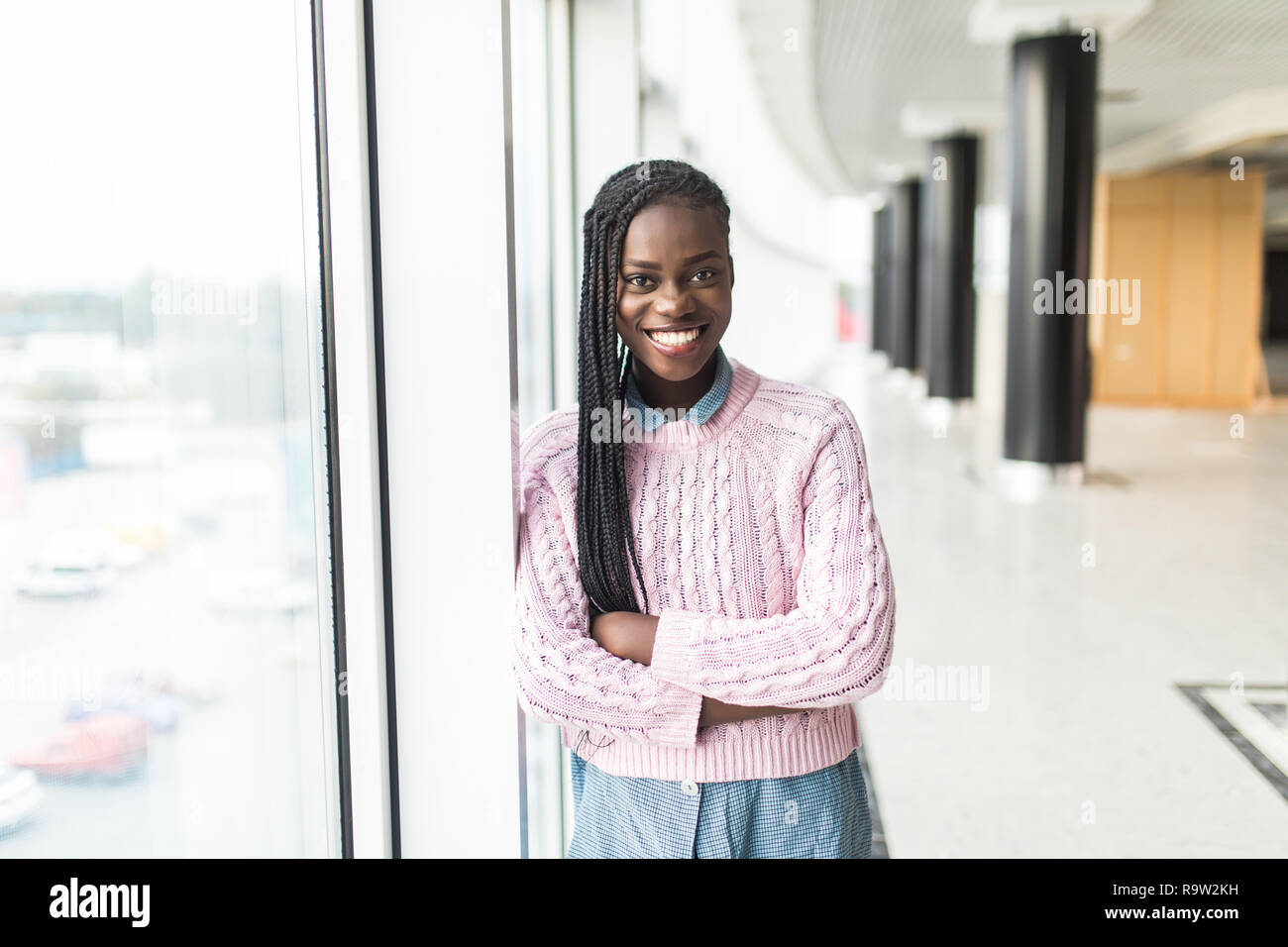 Attractive young businesswoman staring thoughtfully through office ...