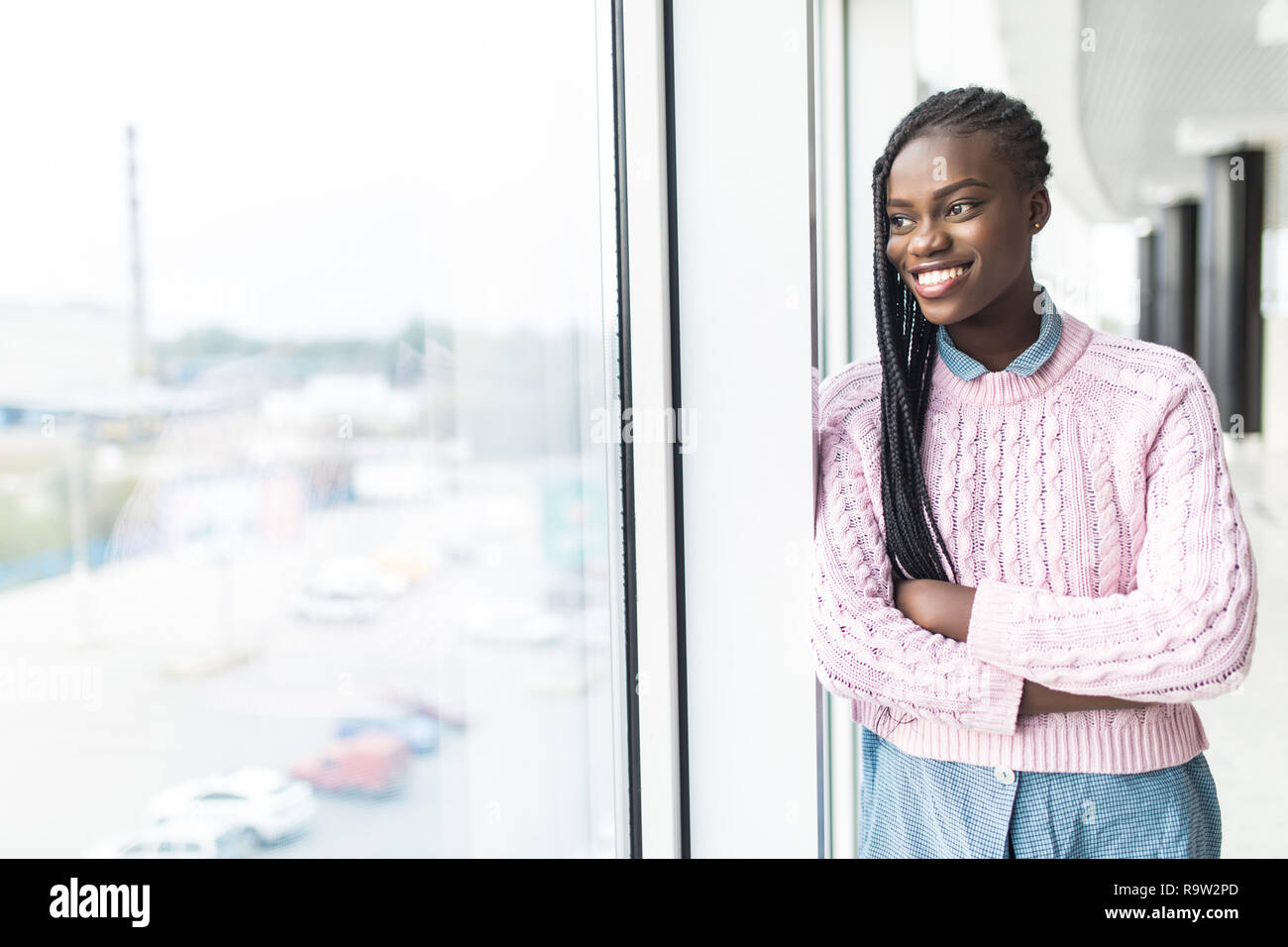 Attractive young businesswoman staring thoughtfully through office ...