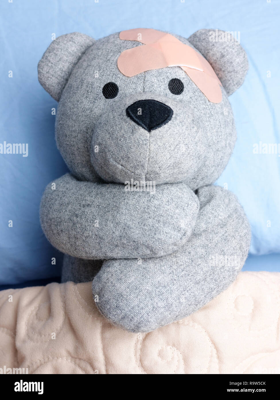 Injured Teddy Bear plasters in the bed hugging Stock Photo - Alamy