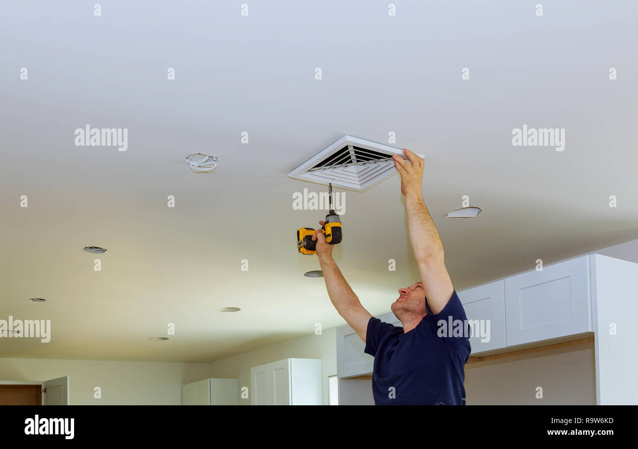 worker builder installing air conditioner ventilation cover ...