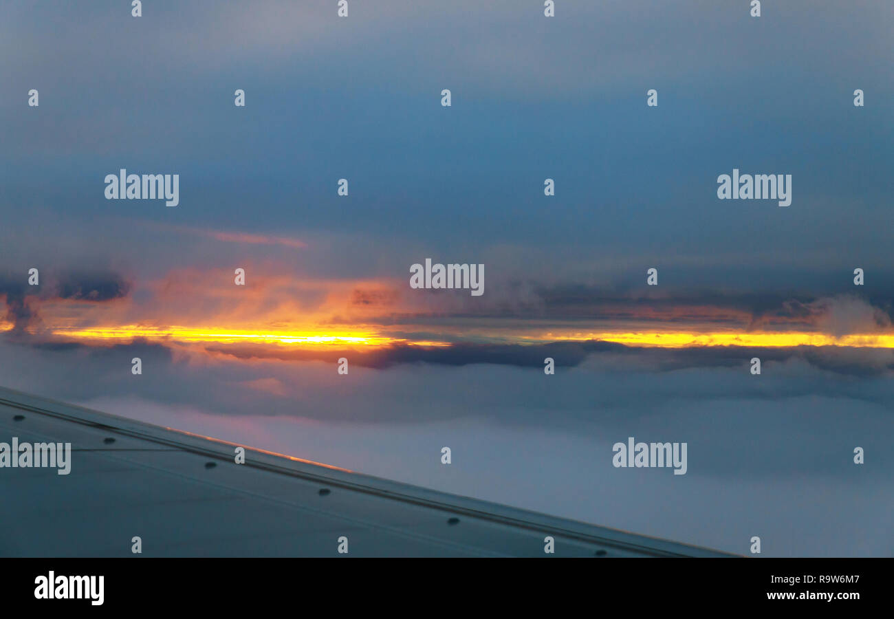 Beautiful sunset clouds and sky as seen through window of an aircraft ...