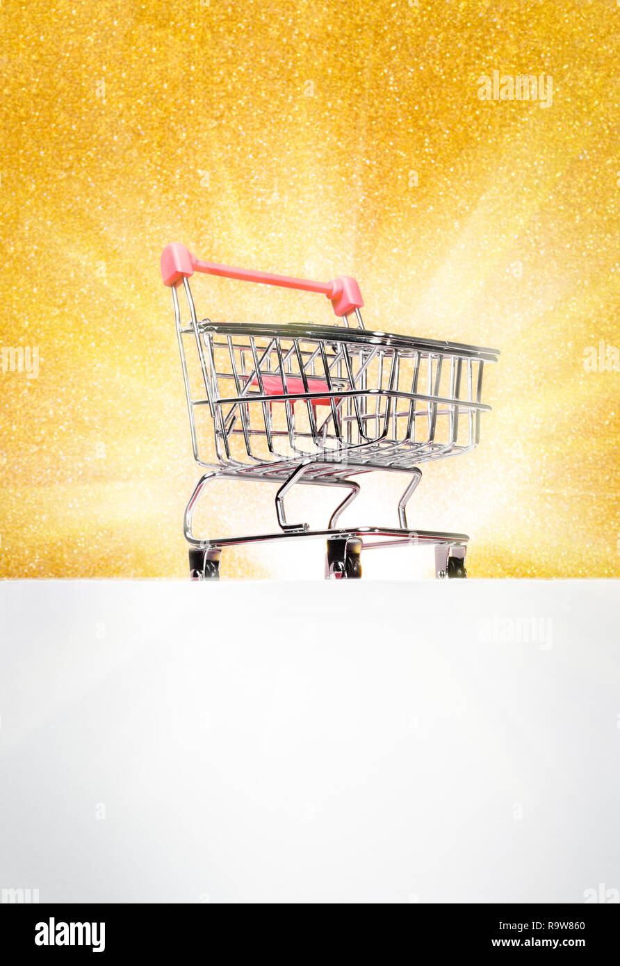 Trolley for shopping on a pedestal on a gold background with a glow ...