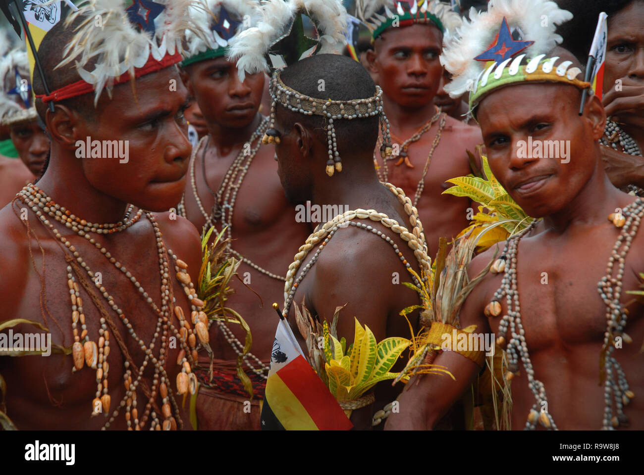 Colourfully dressed and face painted men waiting to join the annual ...