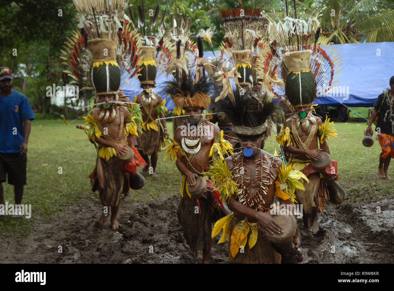Colourfully dressed and face painted men waiting to join the annual ...