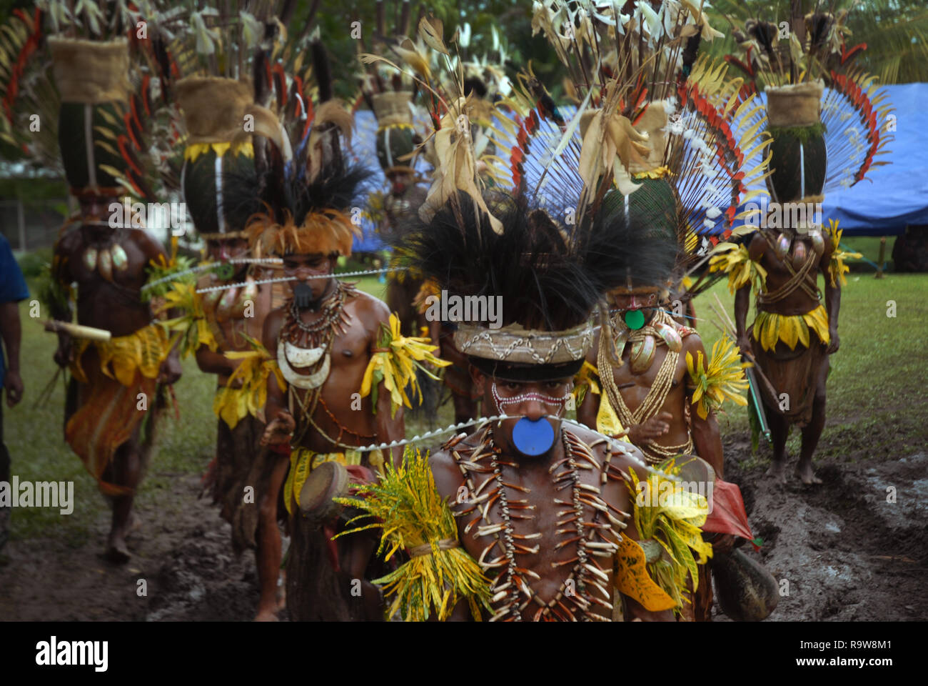 Colourfully dressed and face painted men waiting to join the annual ...