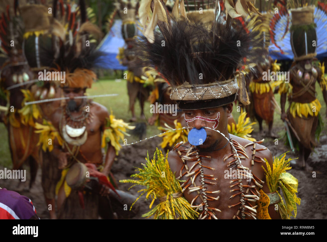 Colourfully dressed and face painted men waiting to join the annual ...