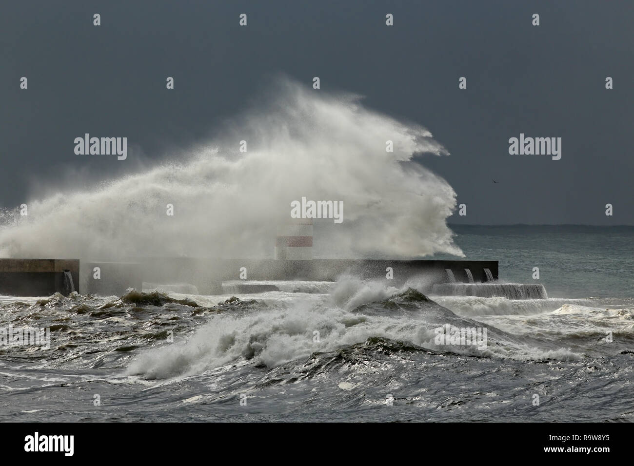 Big windy waves over pier and beacon of the river Douro mouth harbor ...