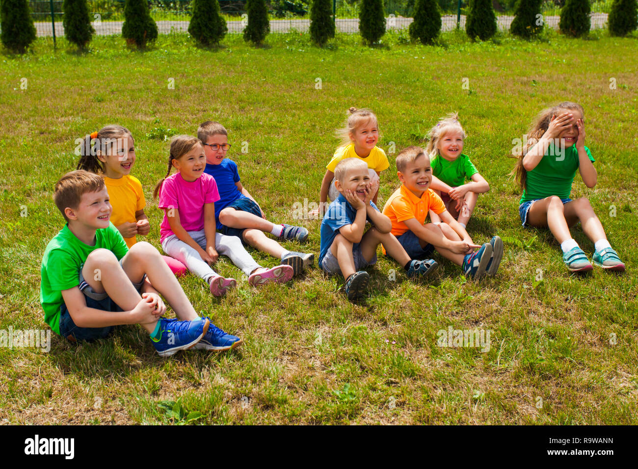 Group of children sitting together on the grass Stock Photo - Alamy
