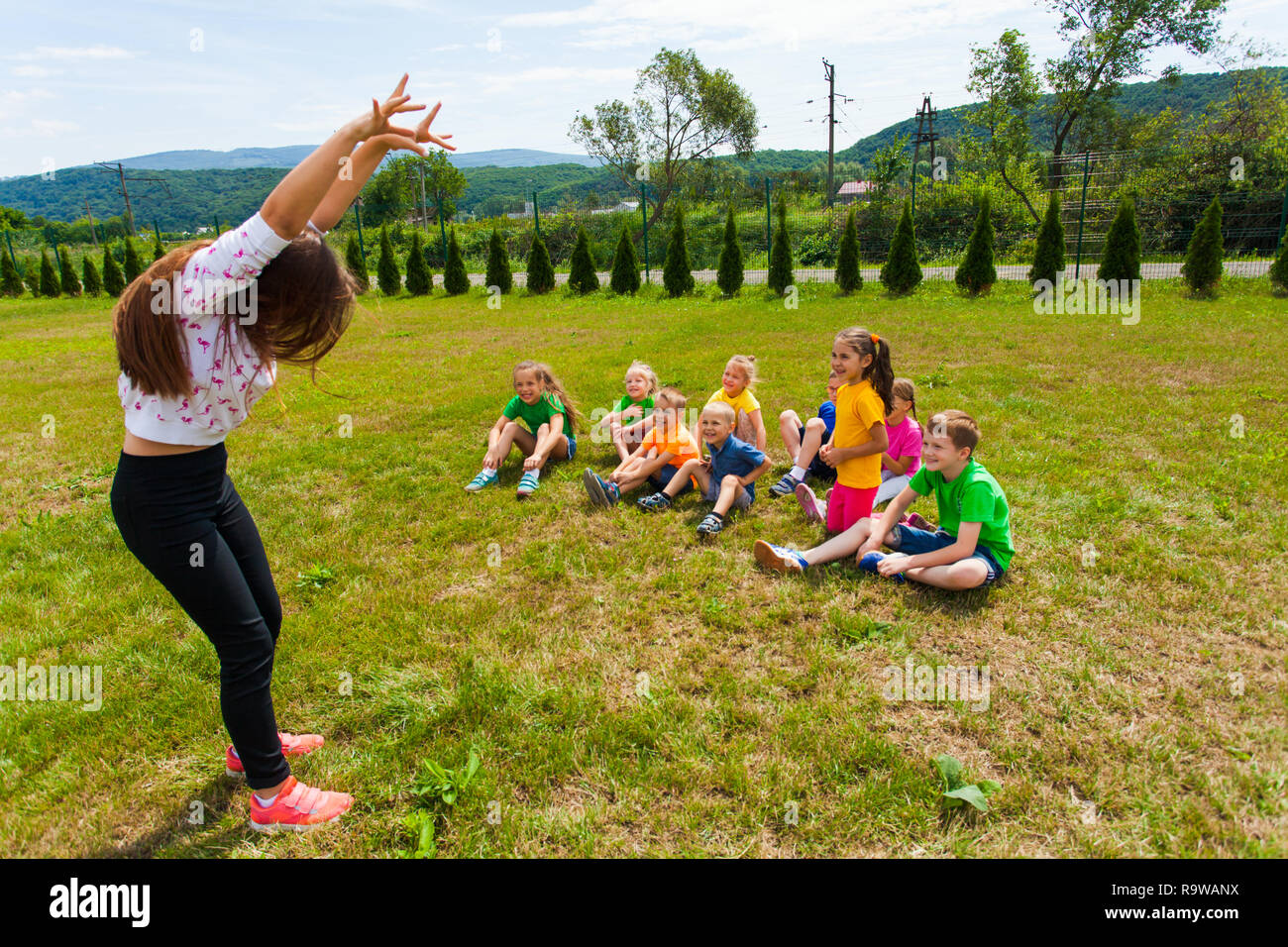 Happy kids guessing during charades game at summer camp Stock Photo - Alamy