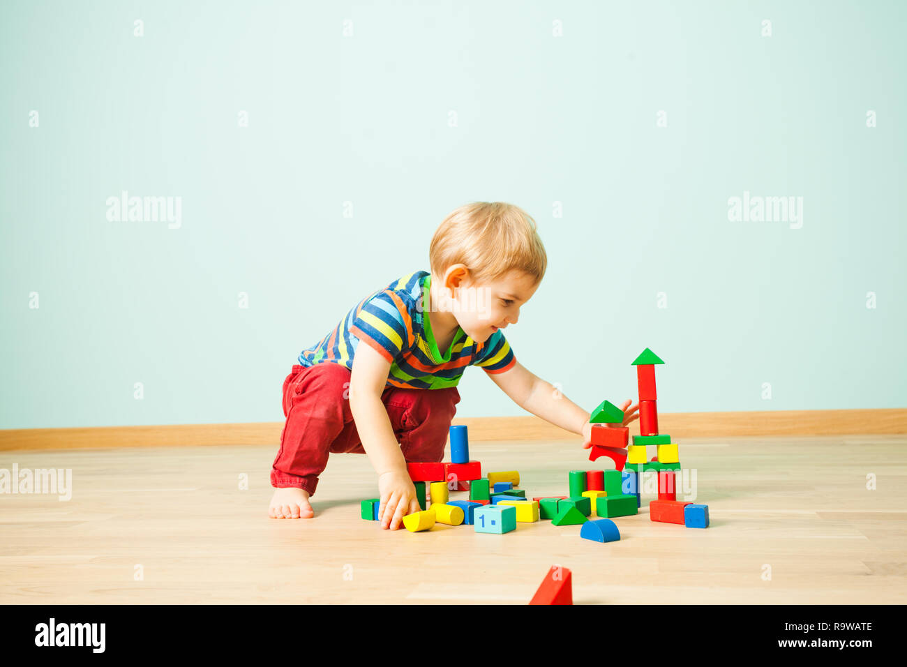 Happy kid smashing toys tower in the kindergarten Stock Photo - Alamy