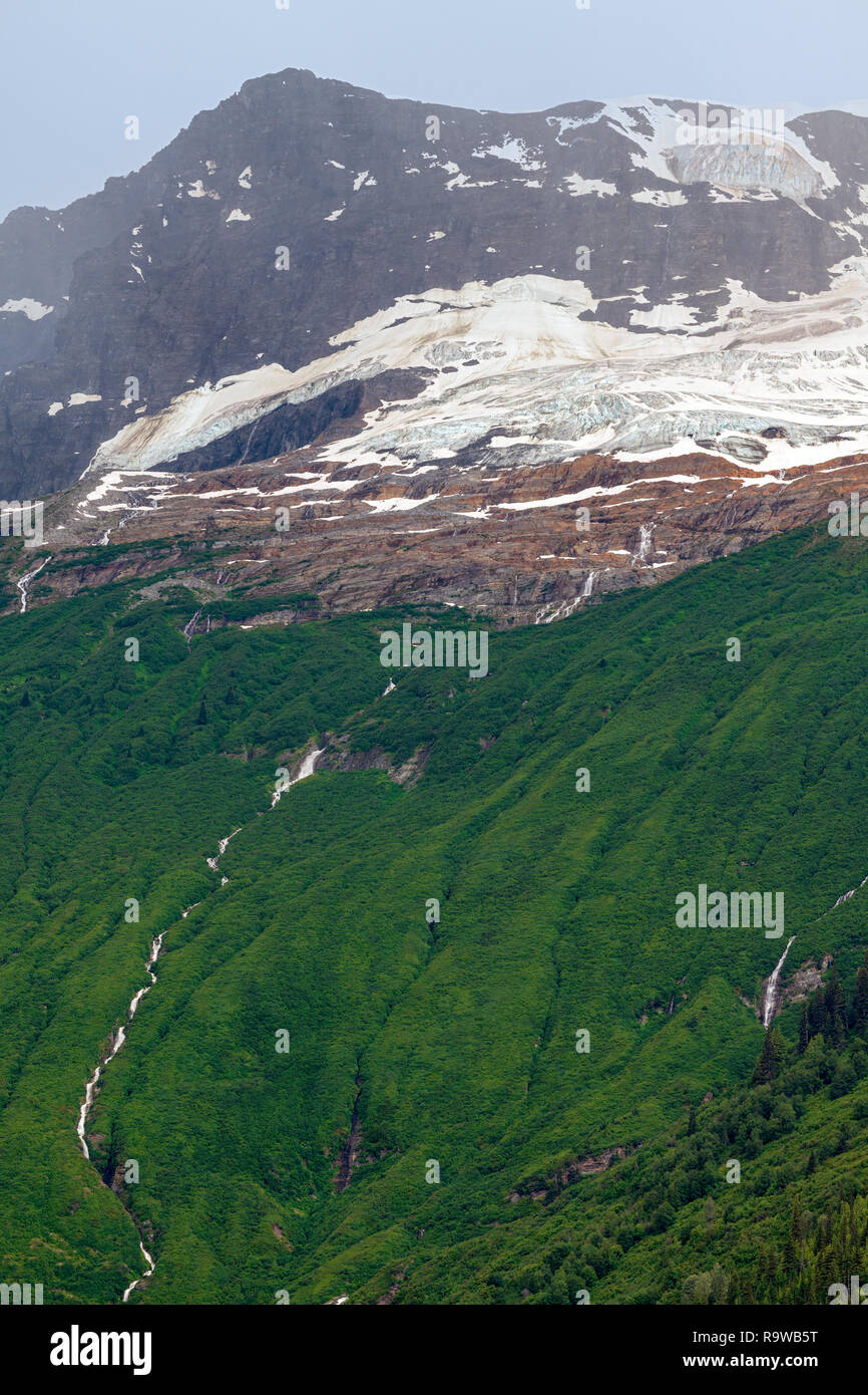 Snowy mountain peak with waterfalls across Kinbasket Lake near ...