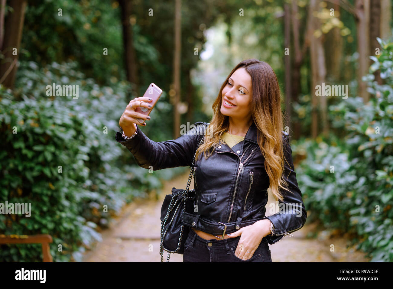 Happy girl taking a selfie in a park full of trees Stock Photo - Alamy