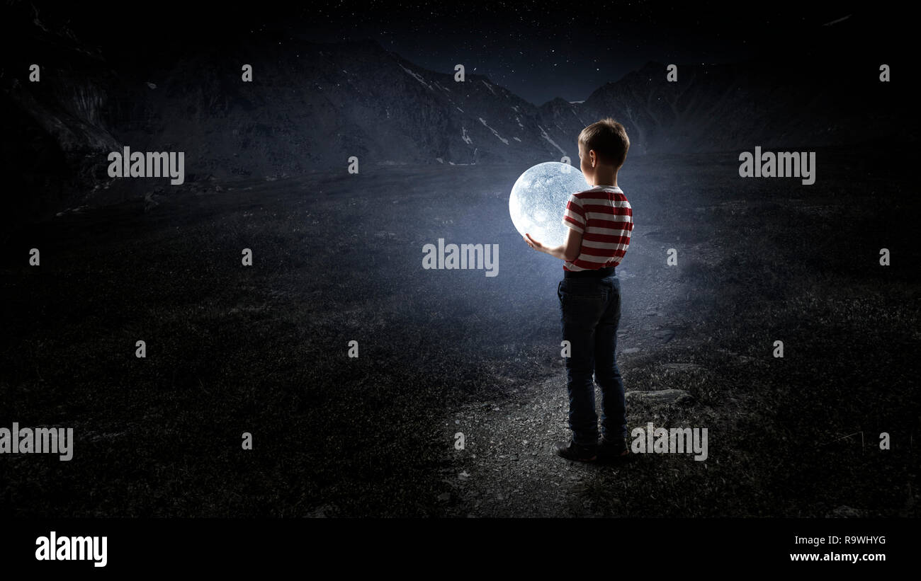 Boy holds the moon . Mixed media Stock Photo - Alamy