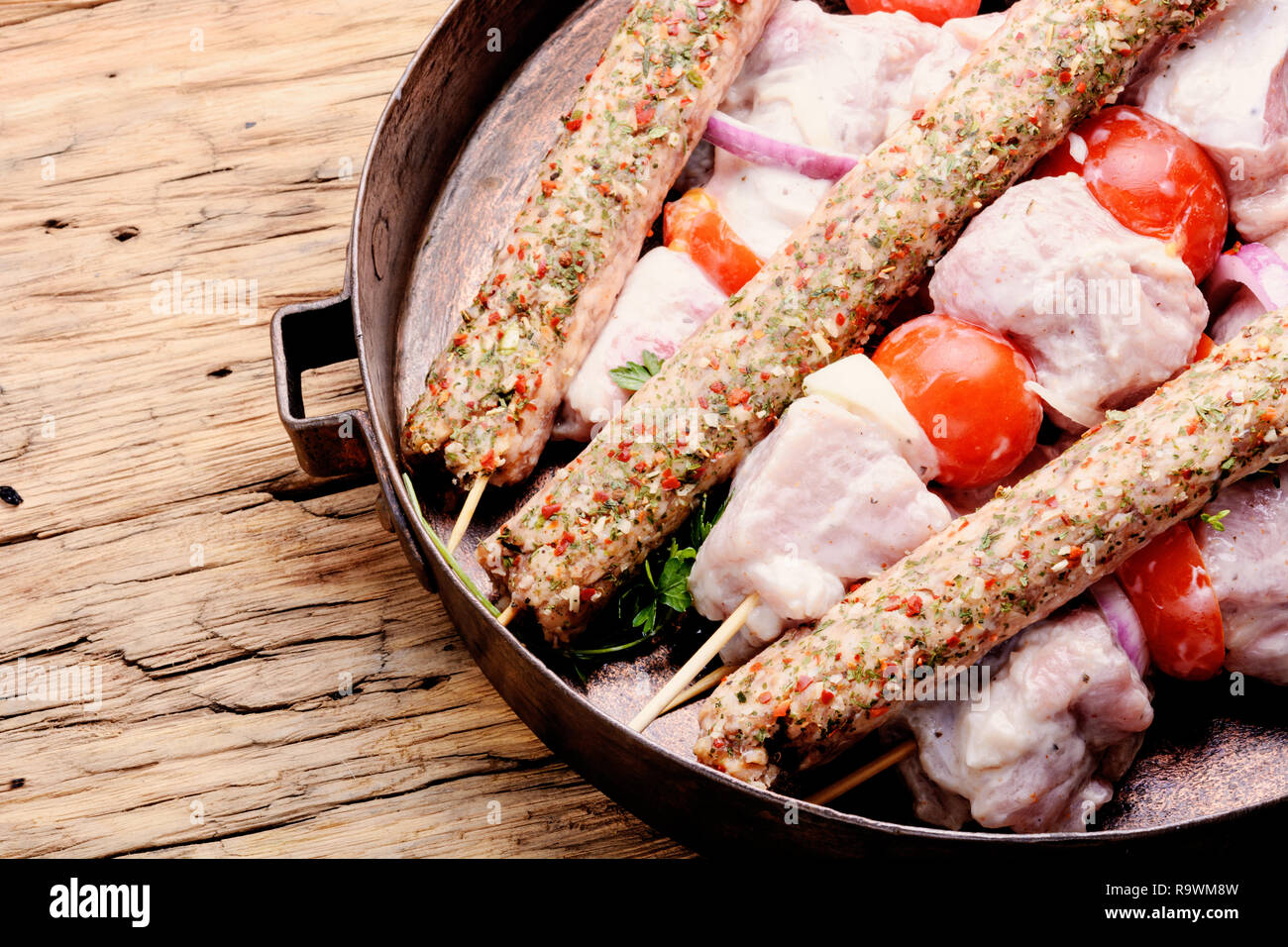 Raw kebab from meat on a wooden background with vegetables Stock Photo ...