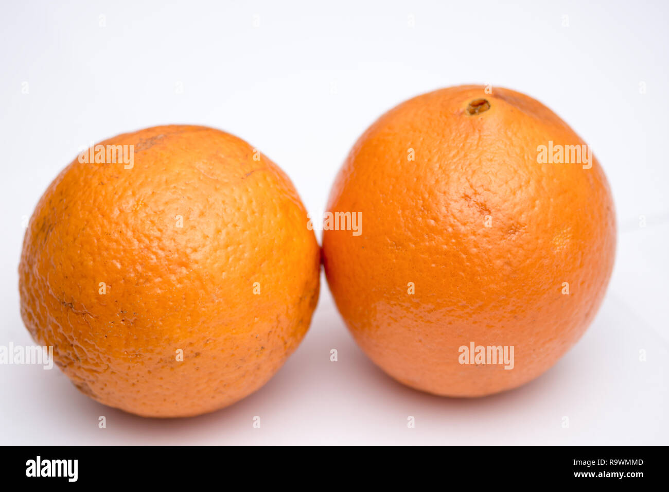 Two whole and unpeeled oranges on the white background Stock Photo - Alamy