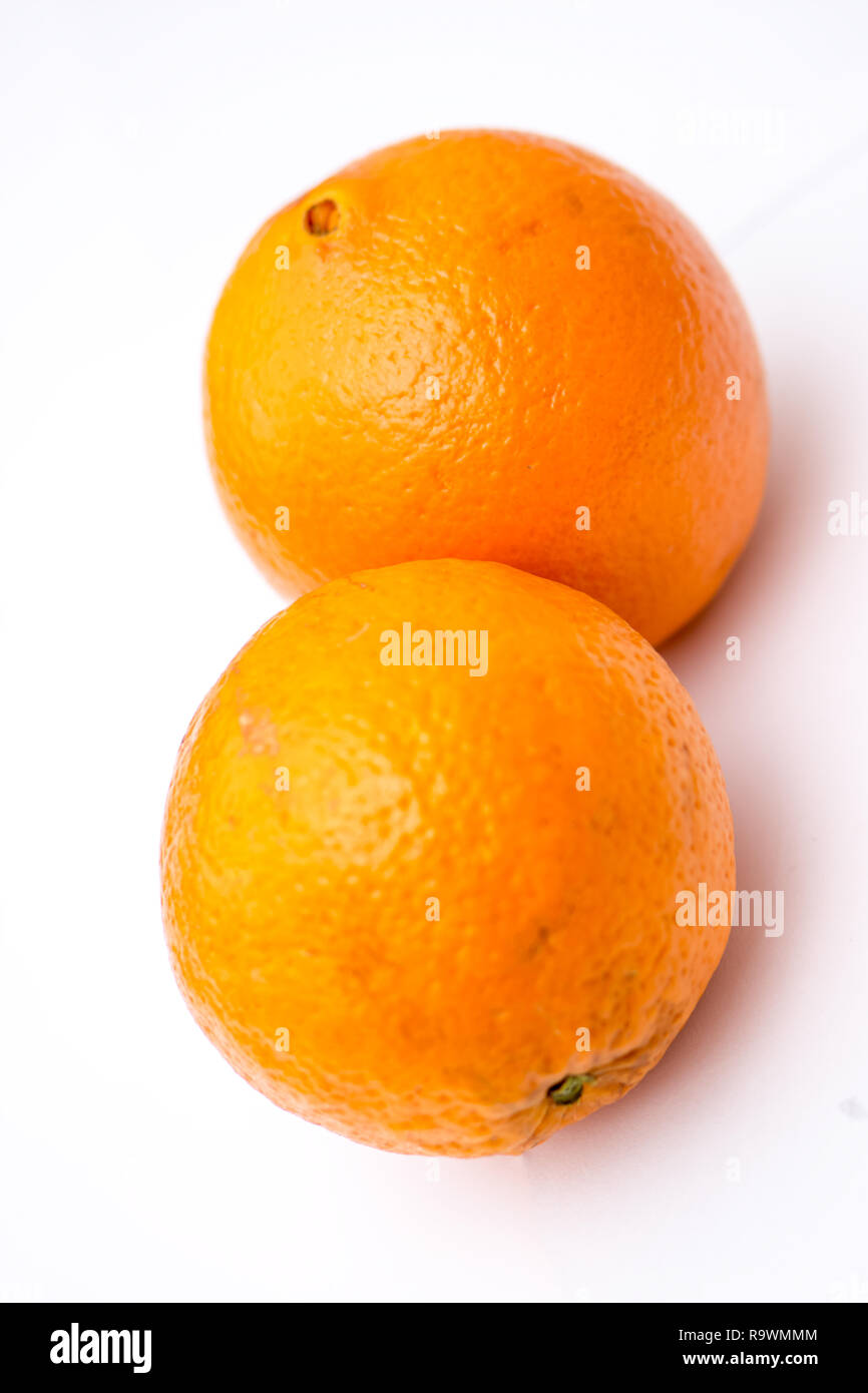 Two whole and unpeeled oranges on the white background Stock Photo - Alamy