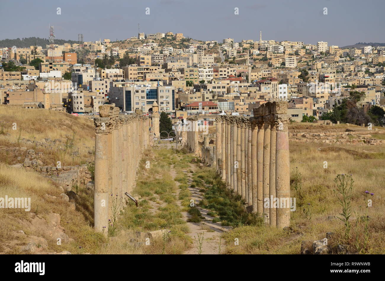 The ancient ruins of Jerash with modern day Jerash city in the ...