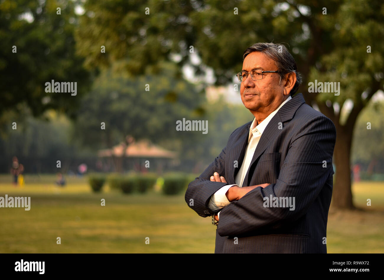 Happy senior Indian man wearing a suit in the outside setting standing ...