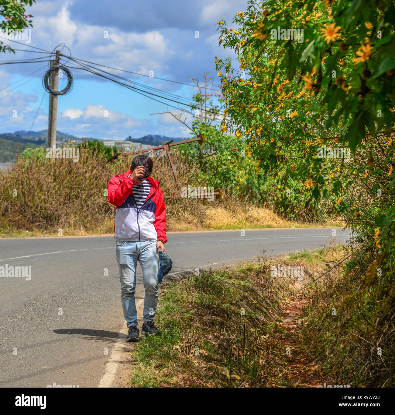 An Asian young man walking on rural road in Dalat, Vietnam Stock Photo ...