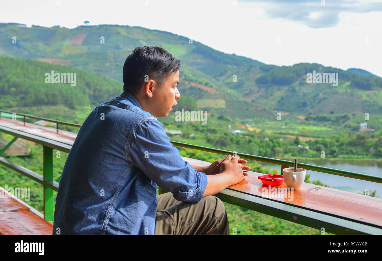 A young man relaxing at mountain view coffee shop in Dalat, Central ...