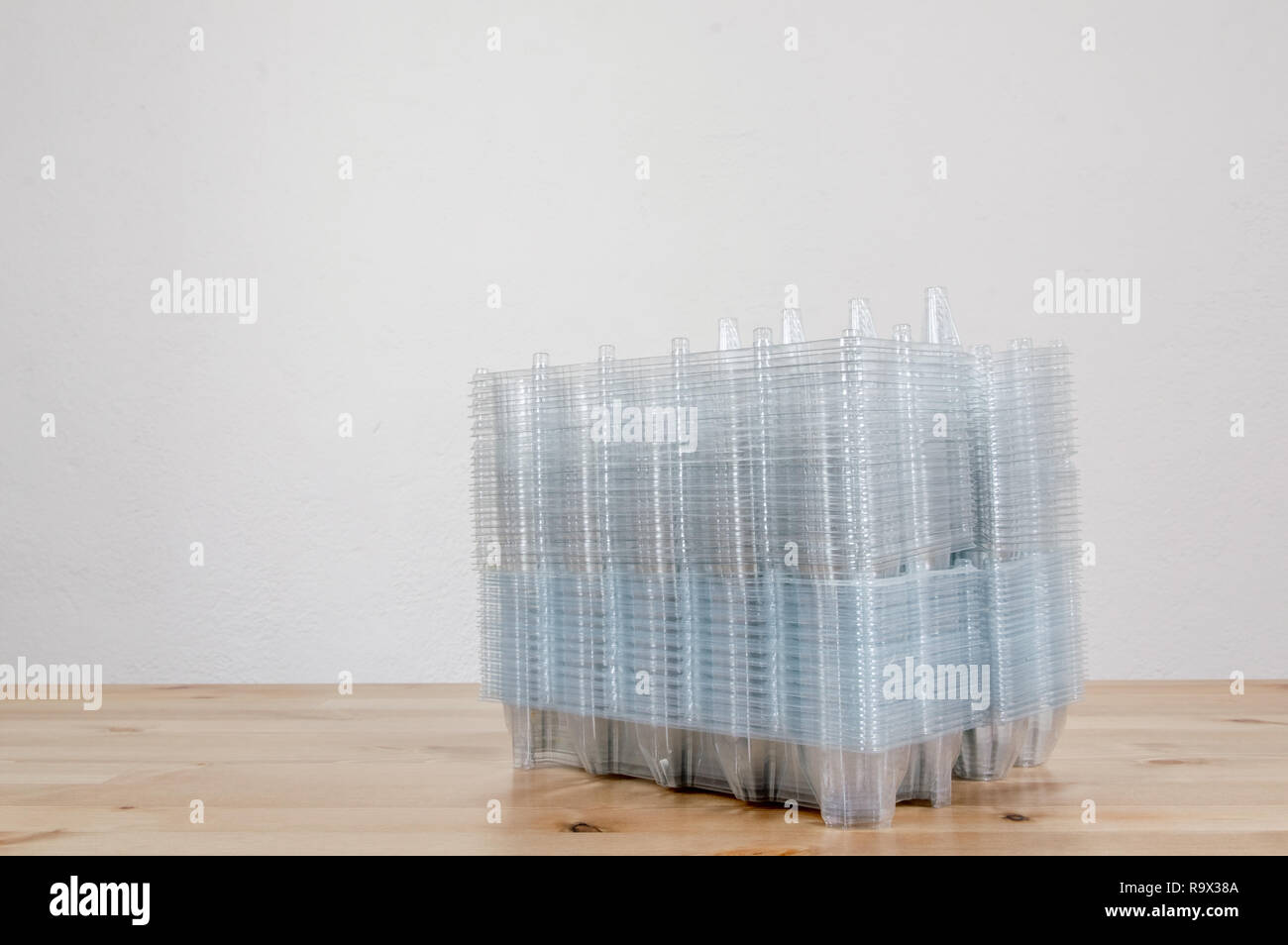 Perspective view of a pile of empty plastic egg packages on a table ...
