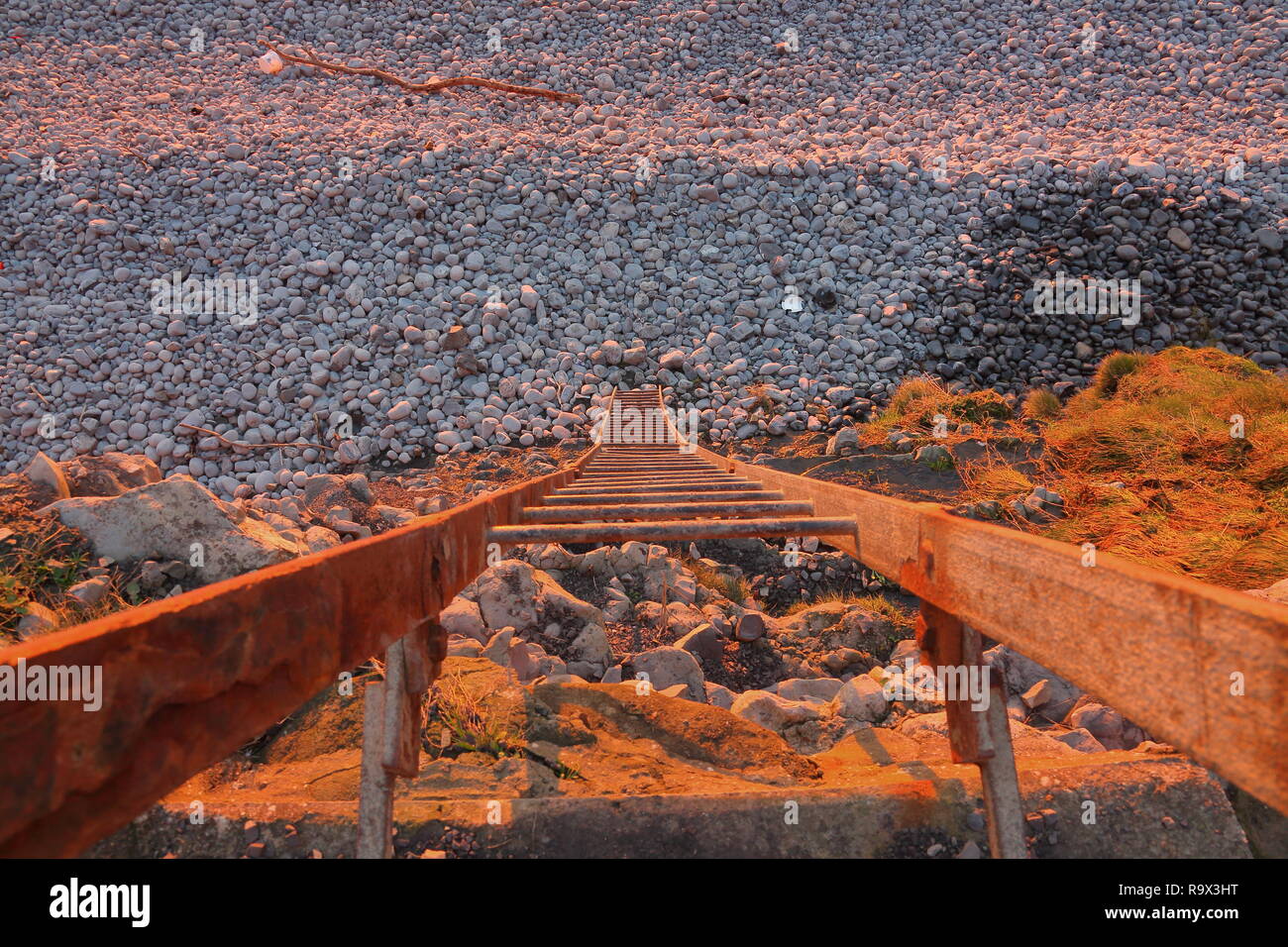 A steel ladder stretching down the vertical cliff face to the beach ...