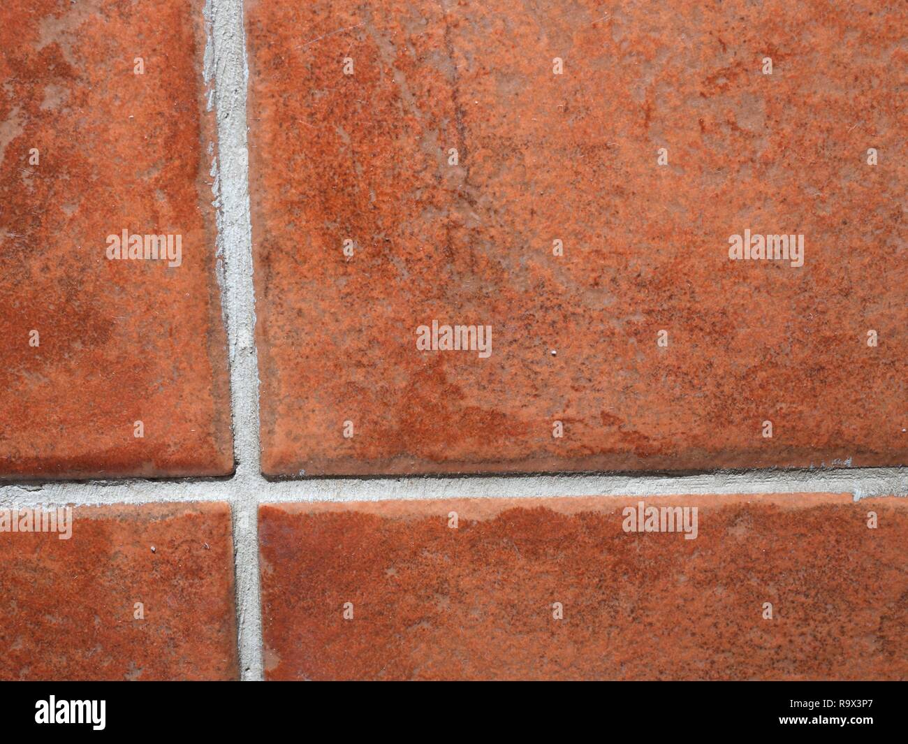 Horizontal rectangular tiled wall in bathroom in detail. Tiles red and ...