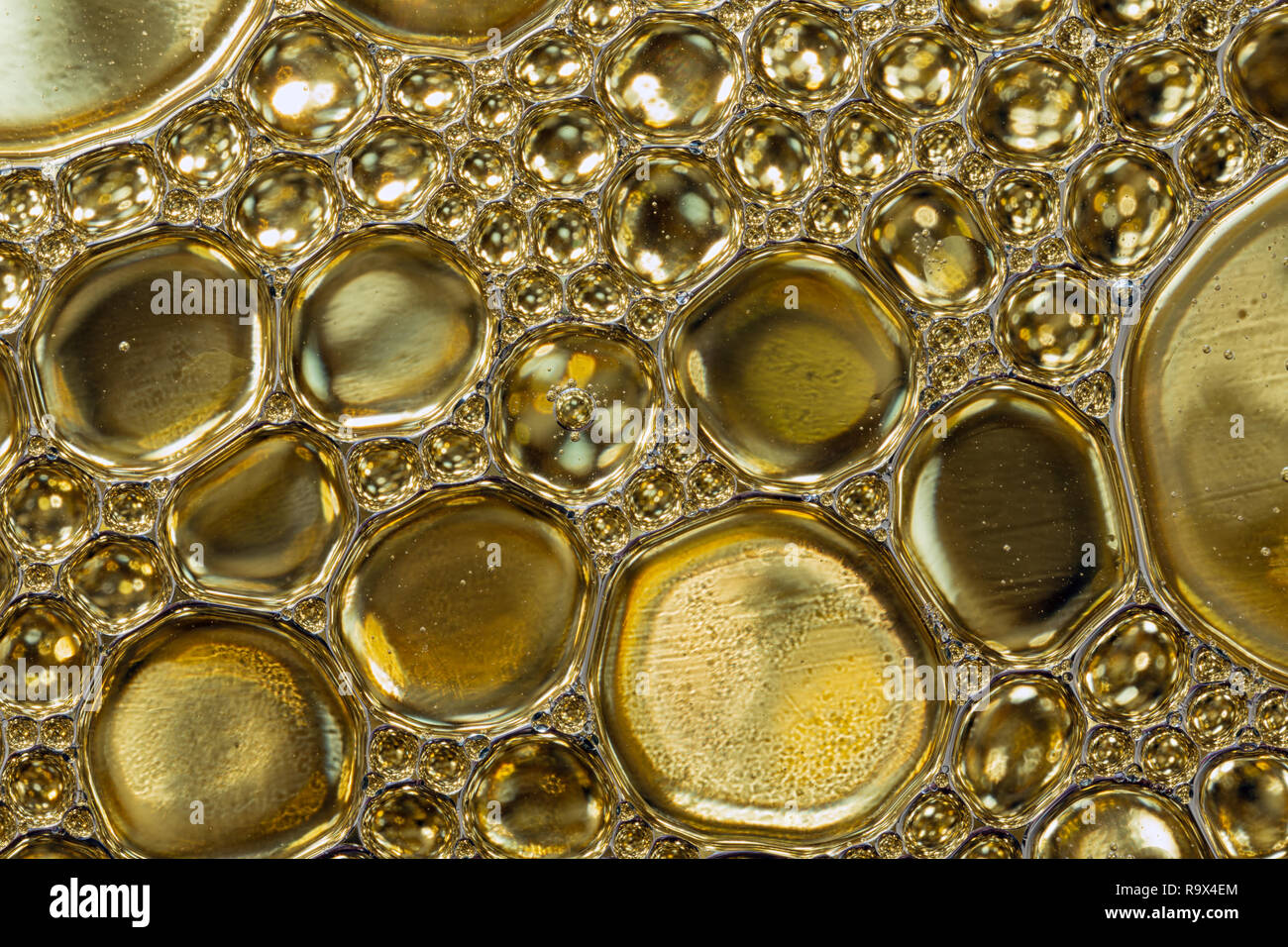Abstract background of gold colored oil drops on water Stock Photo - Alamy