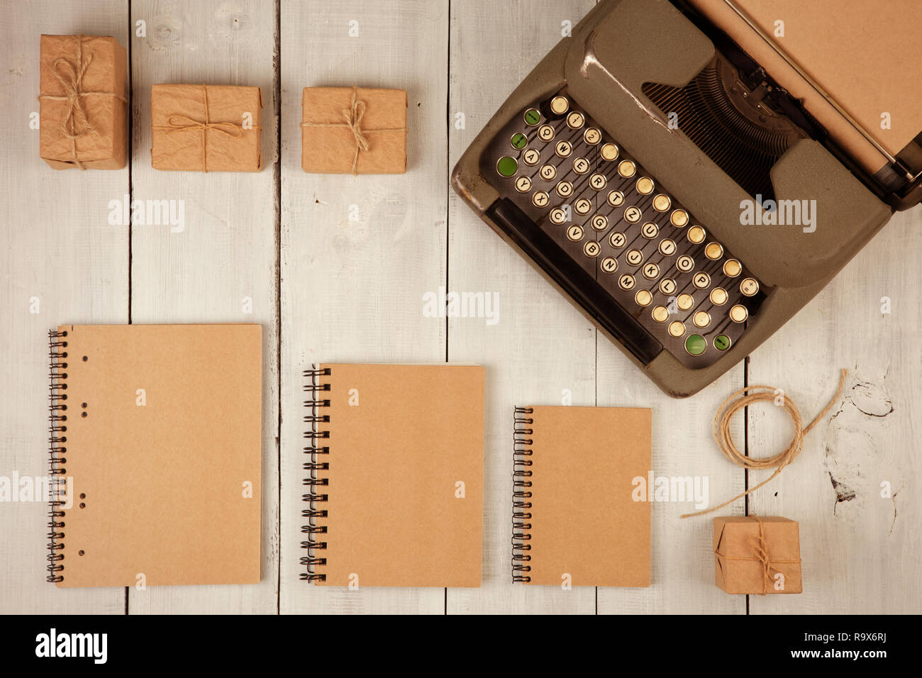 Writer's workplace - vintage typewriter, notepads, present boxes on the ...