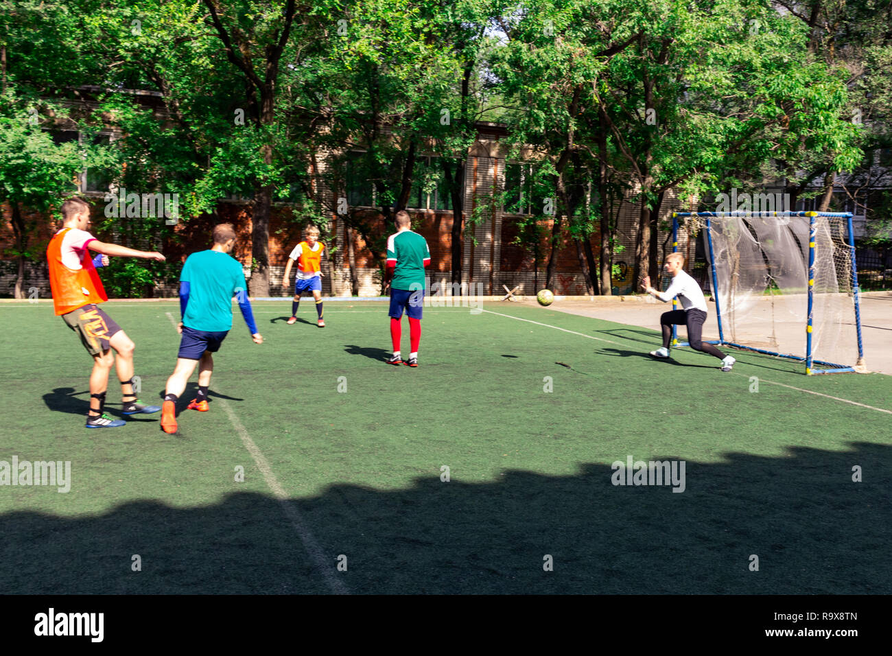 Young people play football on the green grass Stock Photo - Alamy