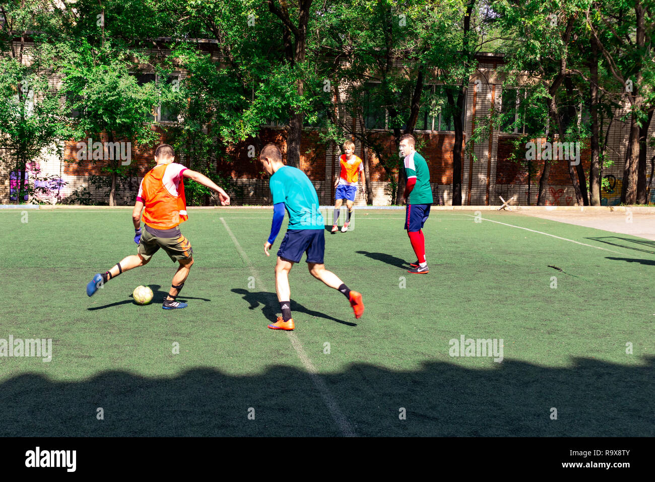 Young people play football on the green grass Stock Photo - Alamy