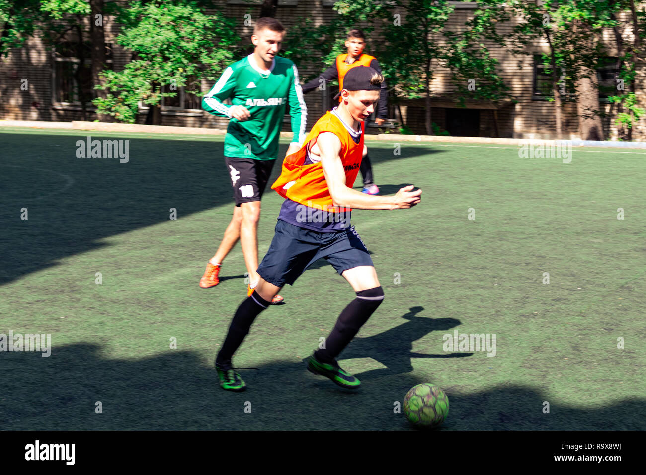 Young people play football on the green grass Stock Photo - Alamy