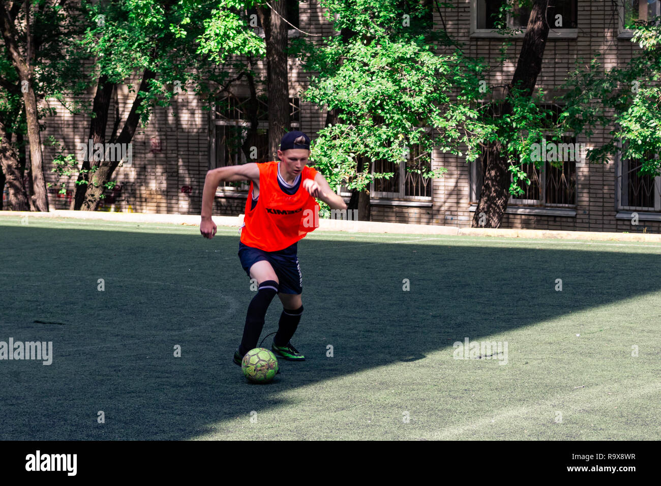 Young people play football on the green grass Stock Photo - Alamy
